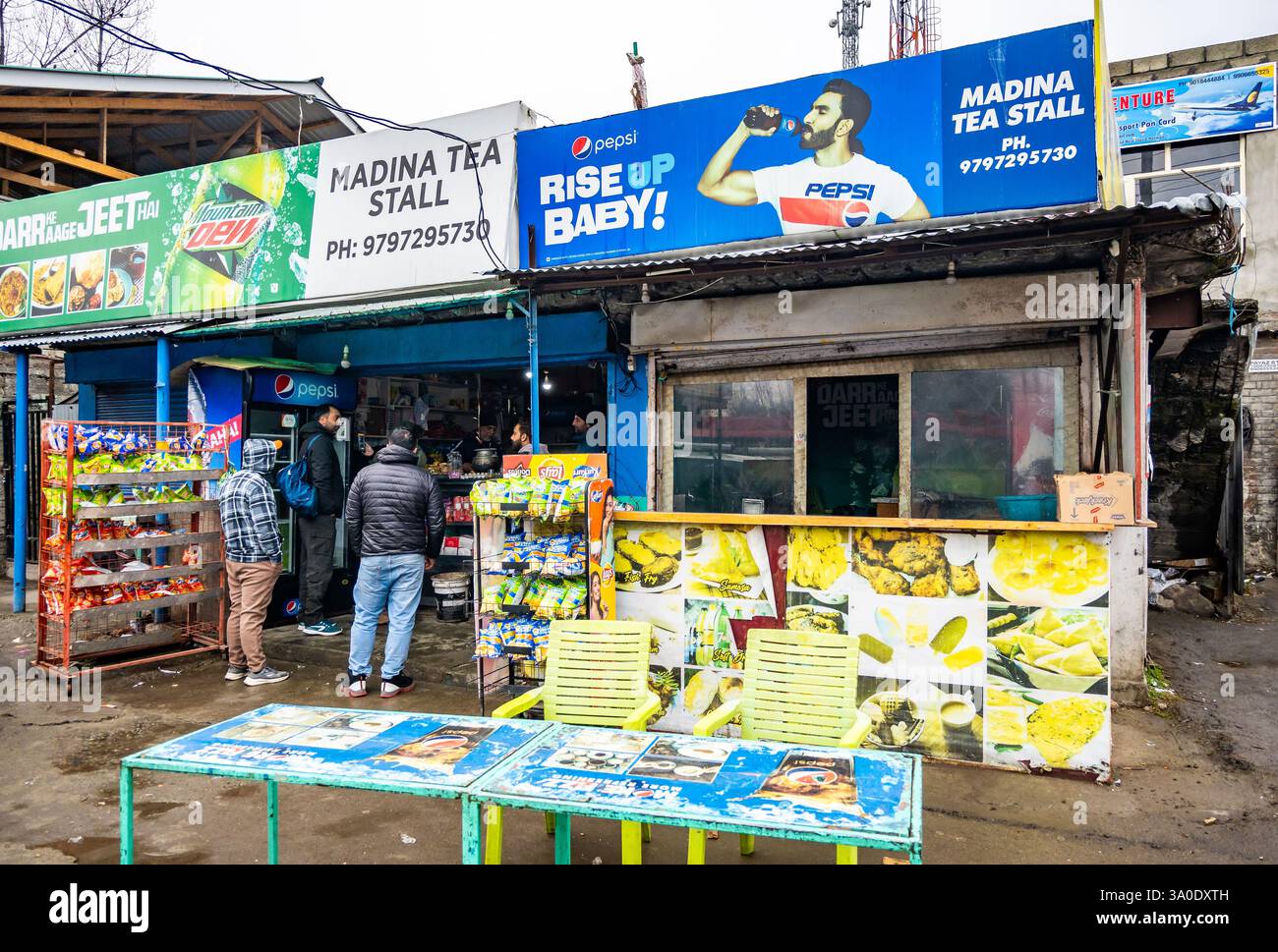 A small roadside store and restaurant with colorful ads. Srinagar ...
