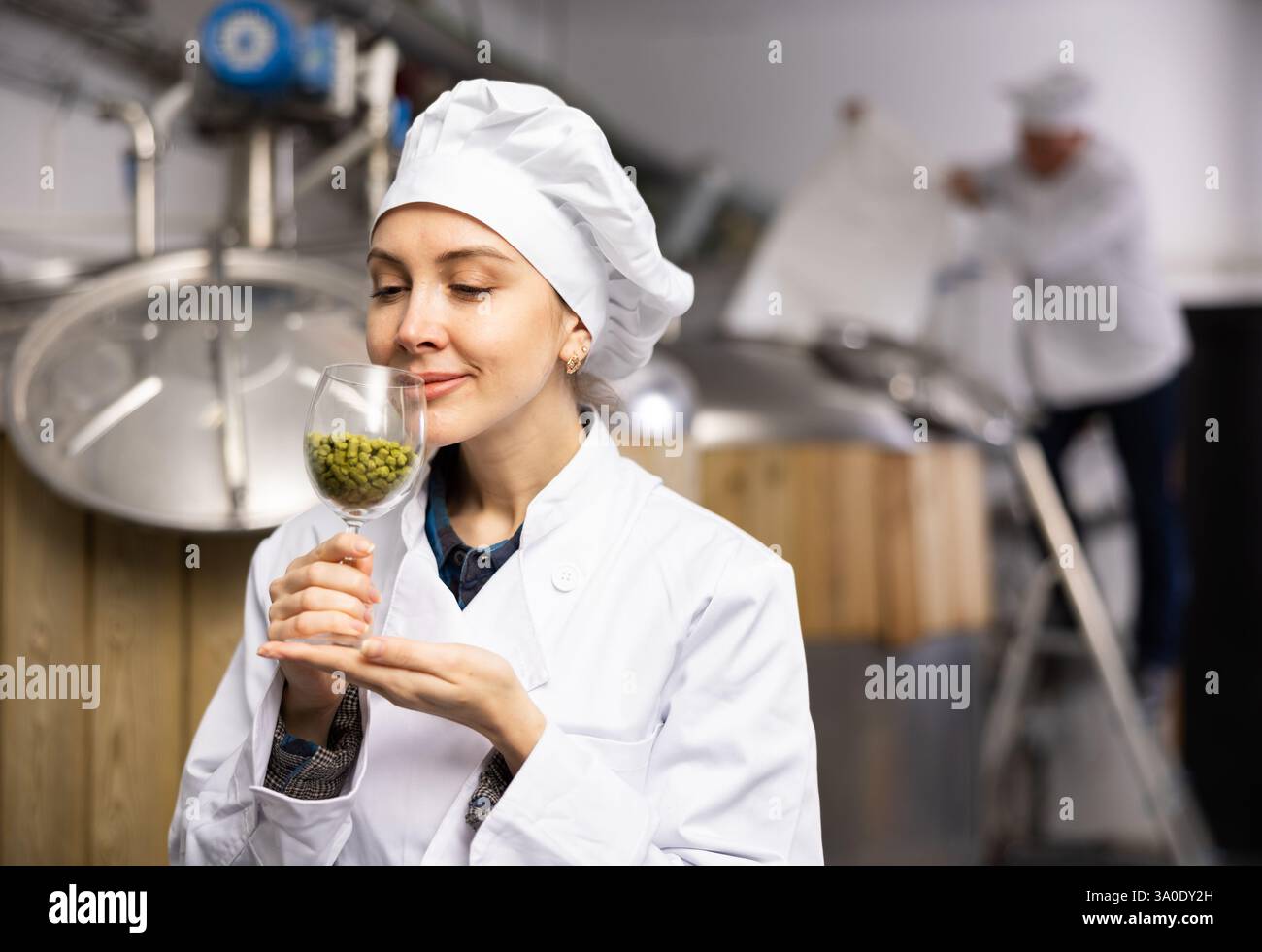 Female brewer smelling hops pellets Stock Photo - Alamy