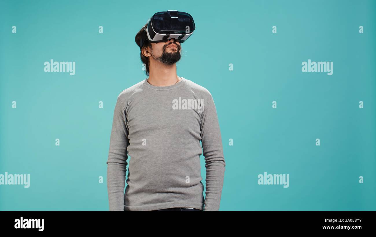 Excited tech fan wearing virtual reality goggles, looking around. Arab ...