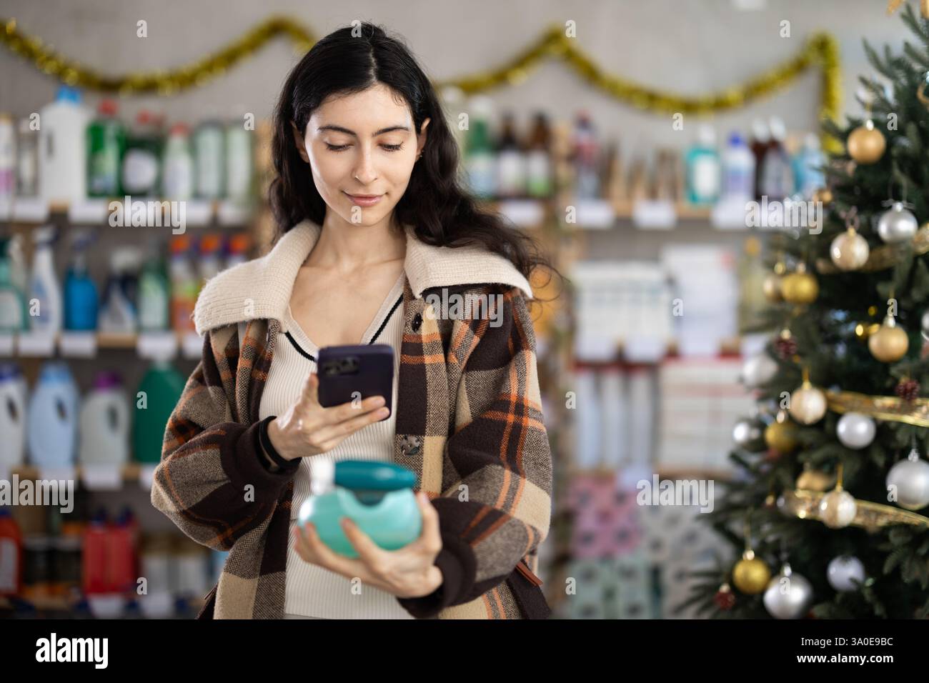 Young woman scanning qr code for cleaning spray Stock Photo - Alamy