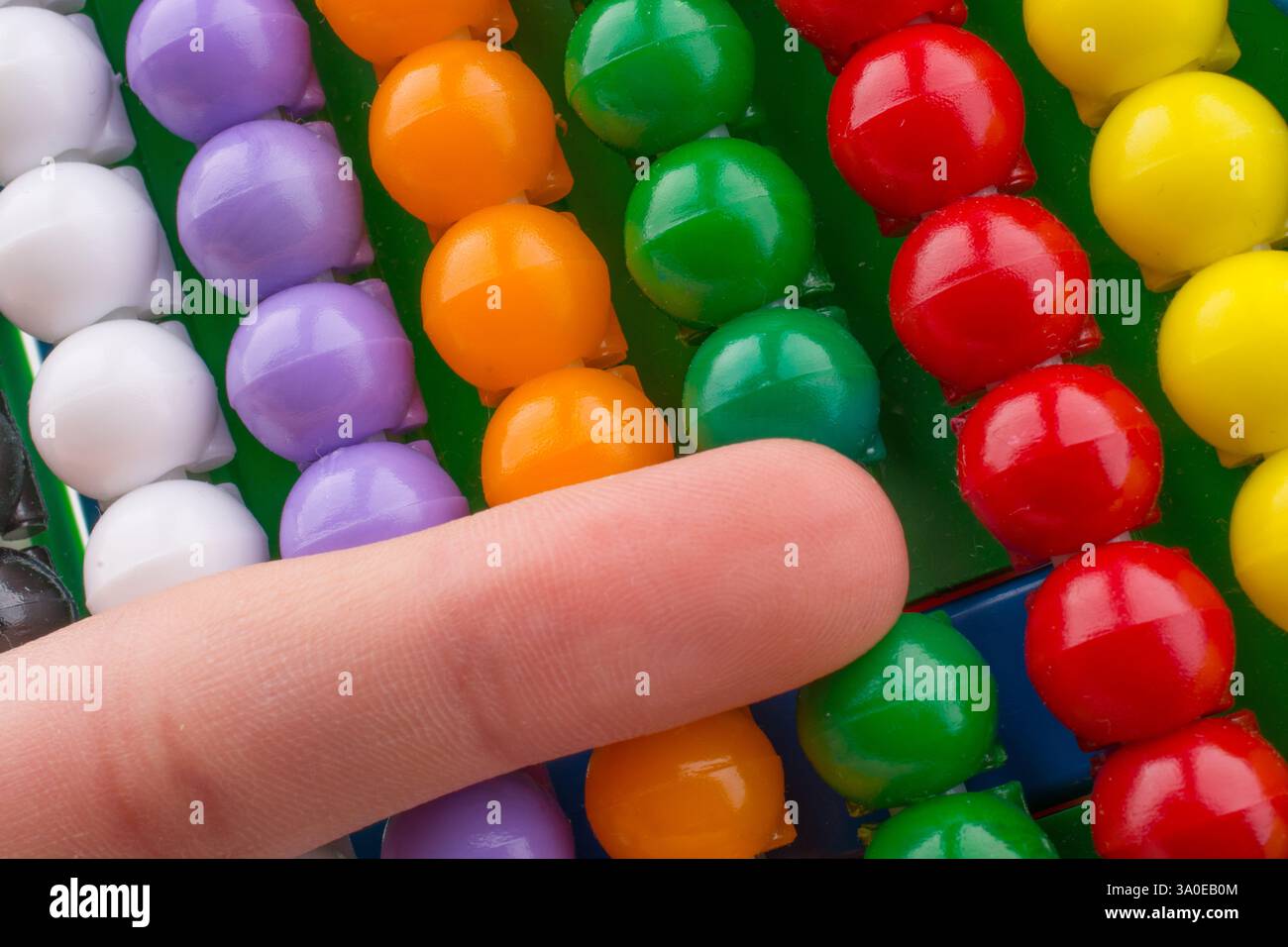 Hand using a color abacus Stock Photo - Alamy