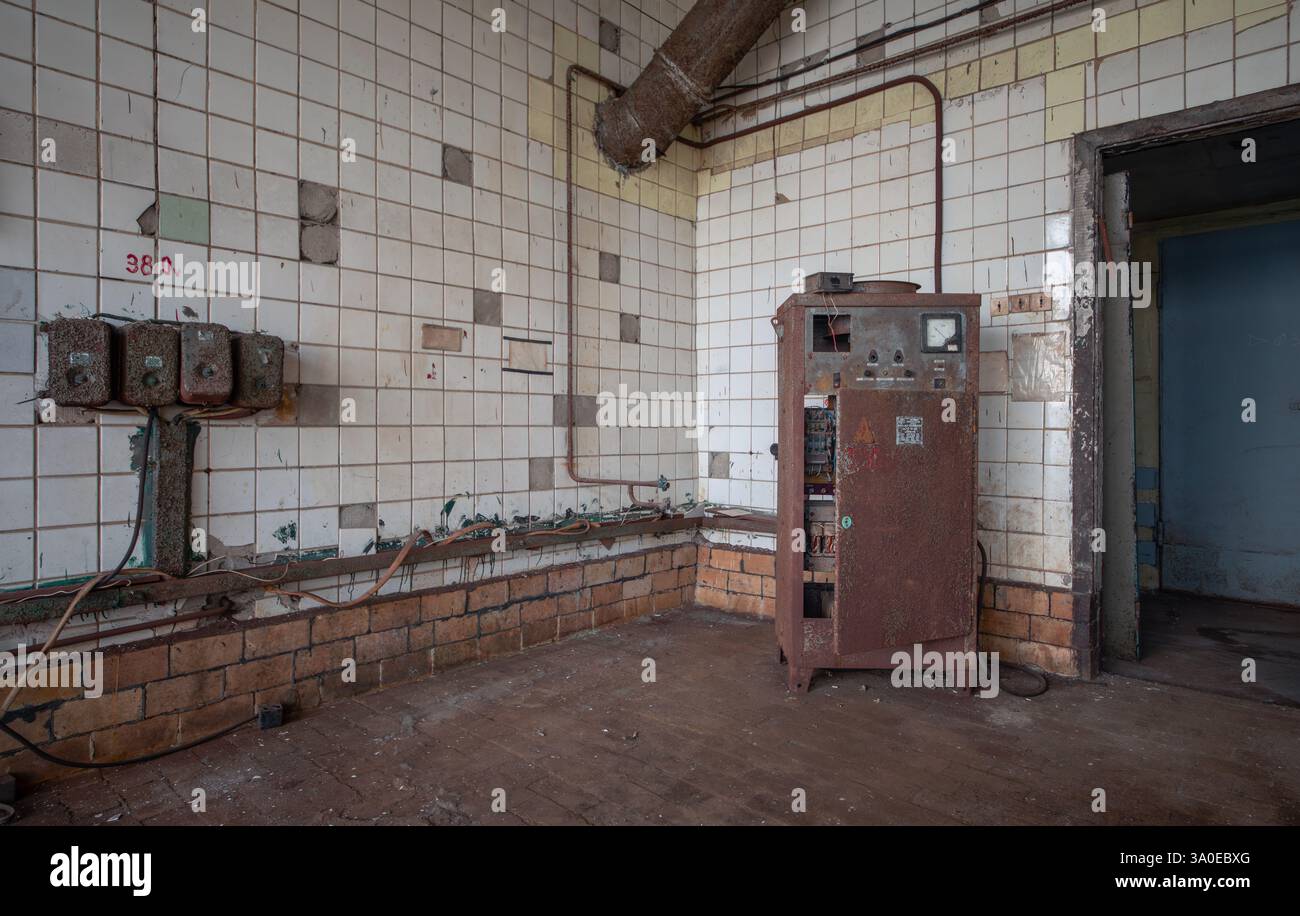 Old, rusty electrical equipment in a room with white tiled walls Stock ...