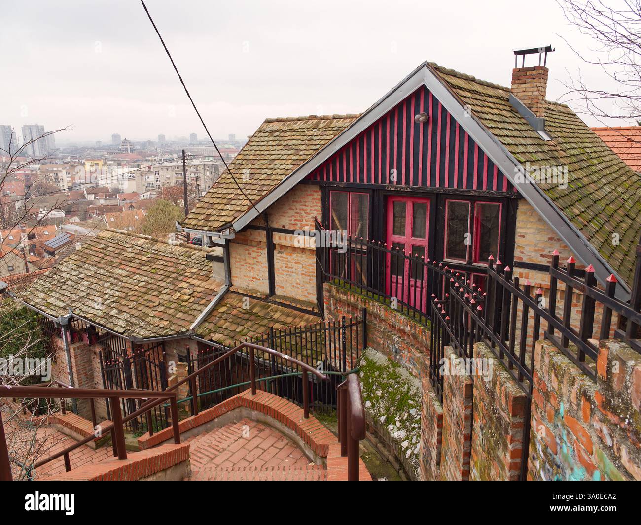Charming rustic house with red trim perched on hill above city skyline ...