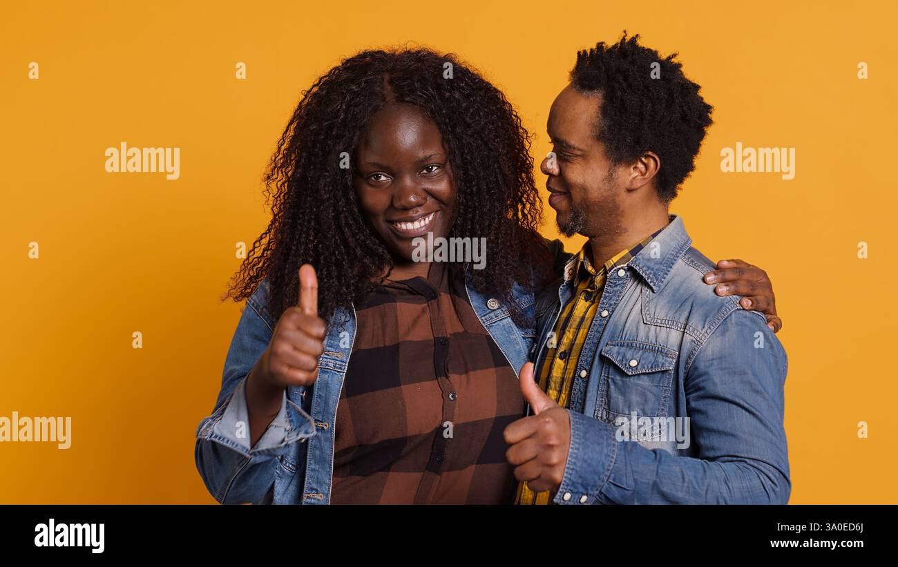 Affectionate husband and wife giving a like symbol on camera, african ...