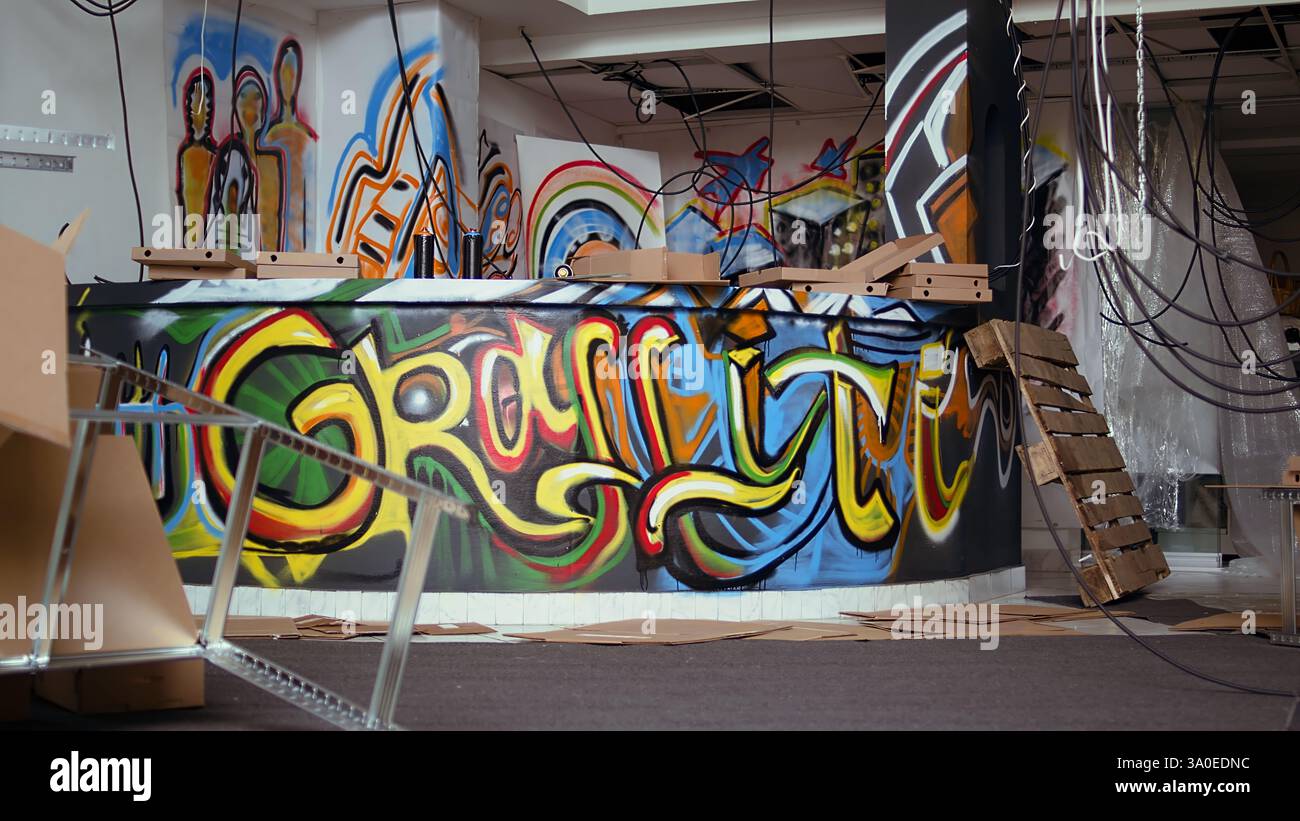 Empty abandoned warehouse with graffiti paintings on walls, concept of ...