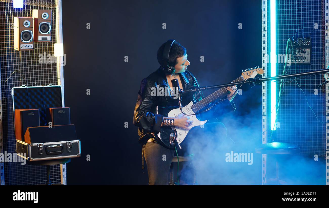 Female rock star singing a heavy metal song while playing her guitar ...