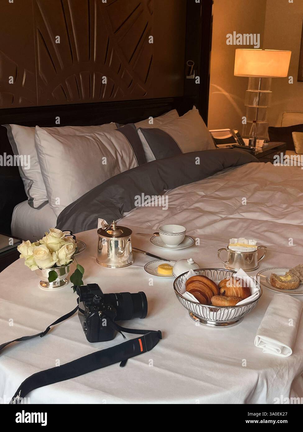 A stylish hotel room has a luxurious breakfast spread and a camera for ...