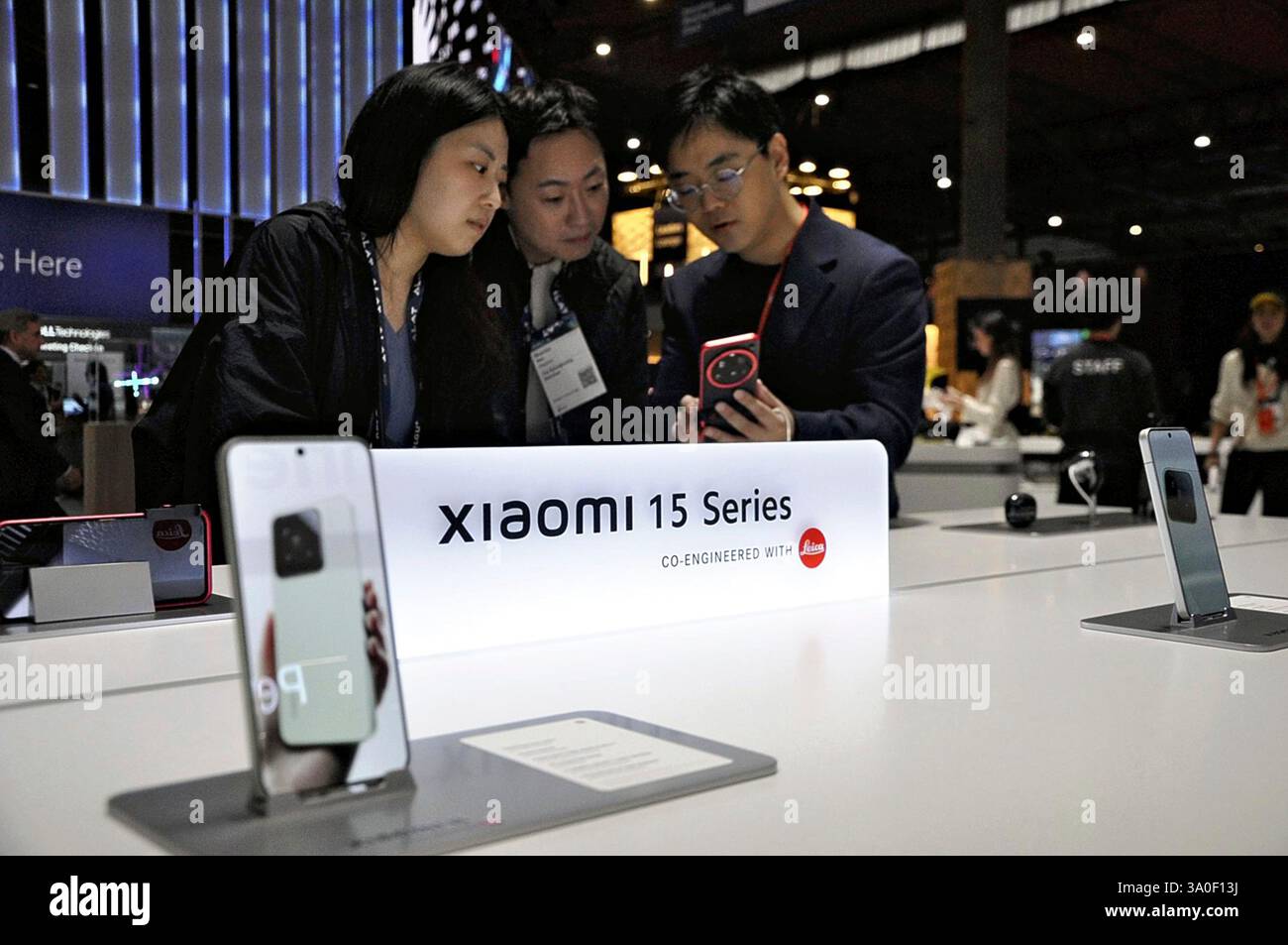 Visitors pick up new smartphones on display at the venue of the MWC ...