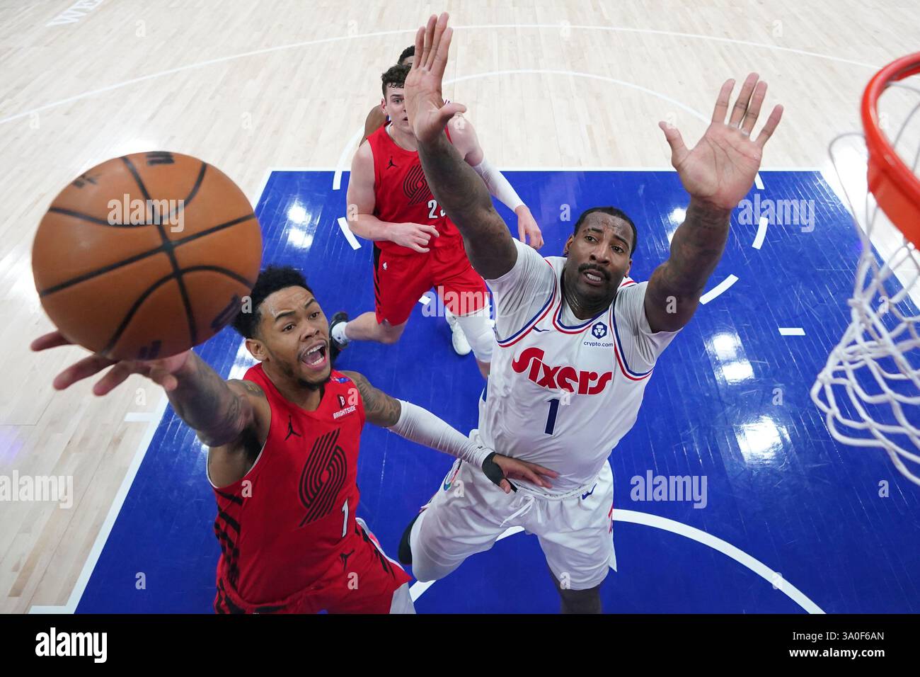 Portland Trail Blazers' Anfernee Simons, left, goes up for a shot ...