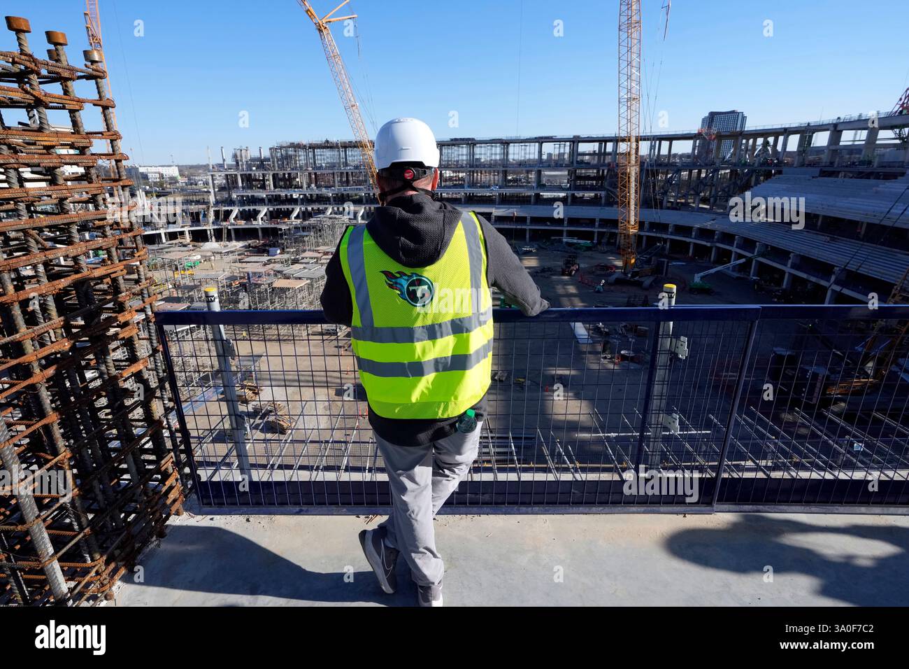 A visitor watches as construction continues on a new enclosed stadium ...