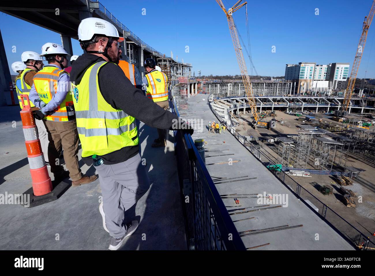 Visitors watch as construction continues on a new enclosed stadium for ...