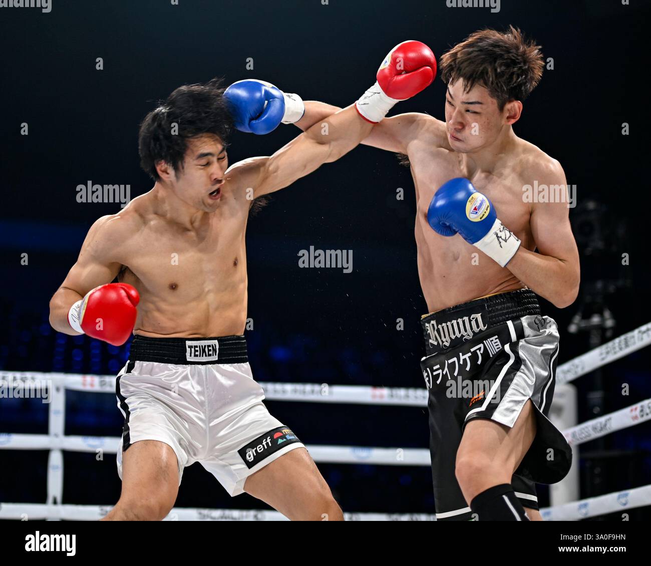 Ryuya Moriai (blue gloves) hits Eigoro Akai (red gloves) in the first ...