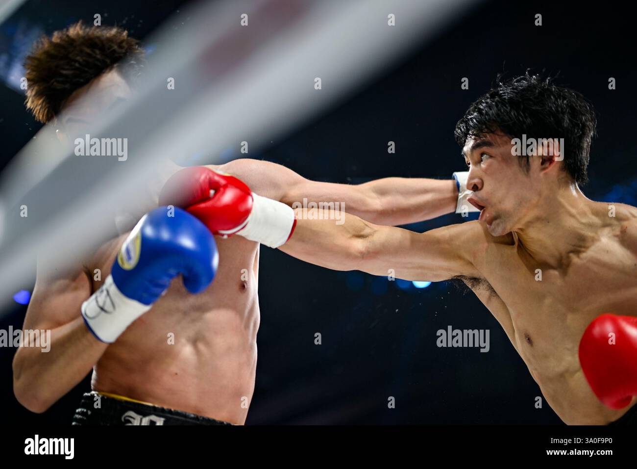 Eigoro Akai (red gloves) hits Ryuya Moriai (blue gloves) in the second ...