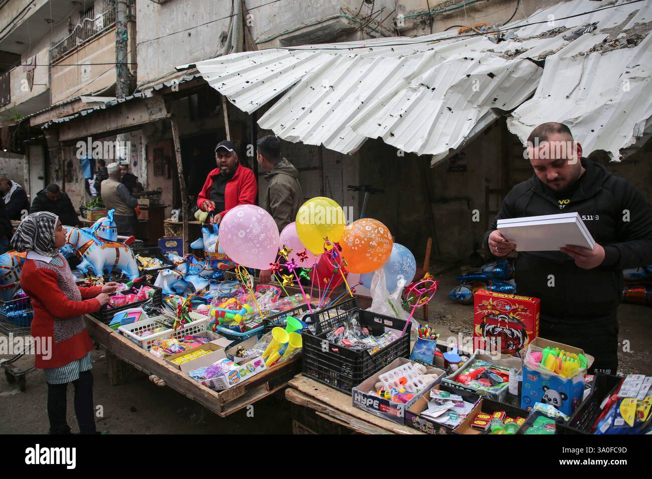 A Palestinian refugee displays Ramadan decorations and toys in his shop ...