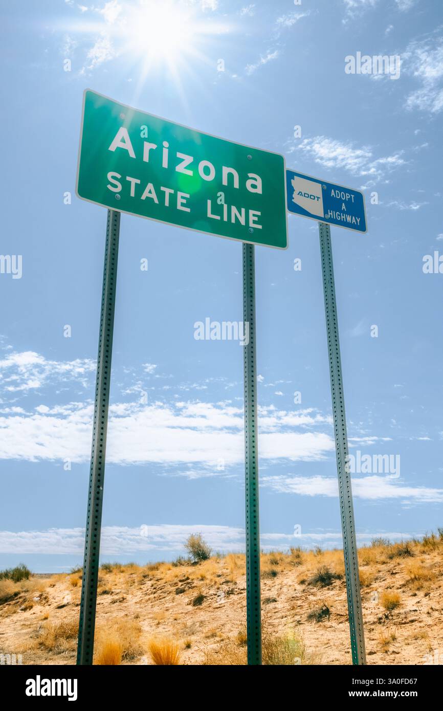 Vertical image of Arizona State Line with adopt a highway sign adjacent ...