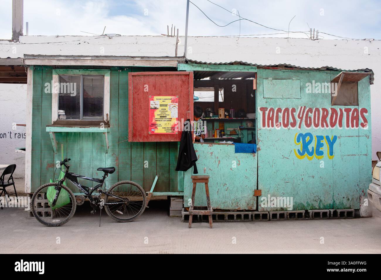 Modest food stand that sells tacos and gorditas, a bicycle parked in ...
