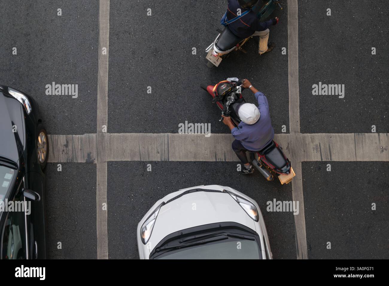 Car and Motorcycle wait to go at intersection with traffic light on a ...