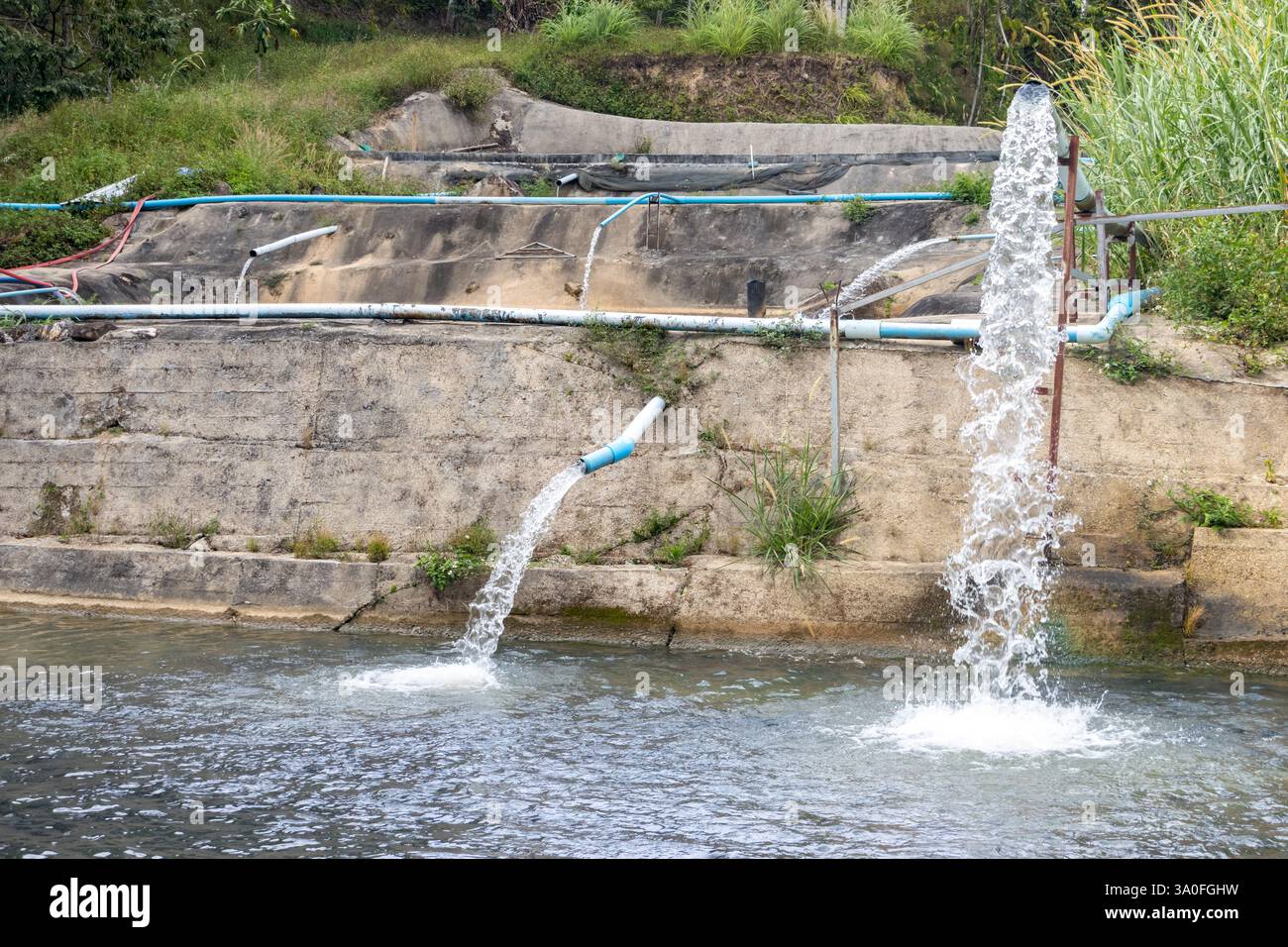 Water flowing from a tubes at cascading ponds for fish breeding ...