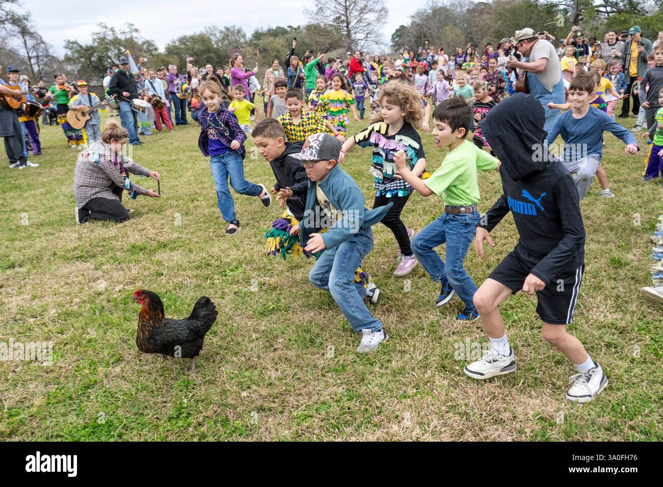 Children are seen runing to chase a chicken during The Teche Center for ...