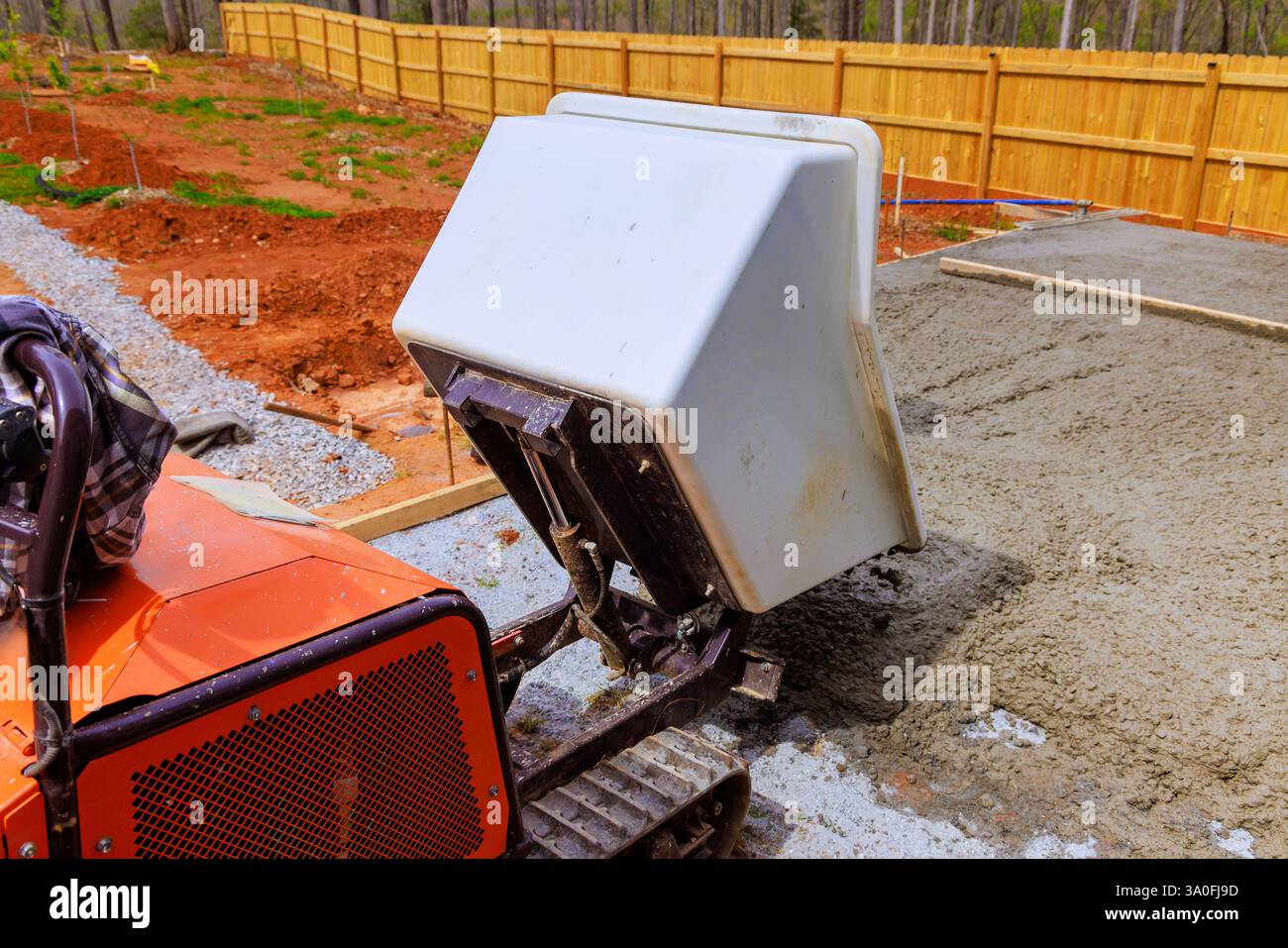 Rubber concrete truck spreads fresh concrete in residential yard, for ...