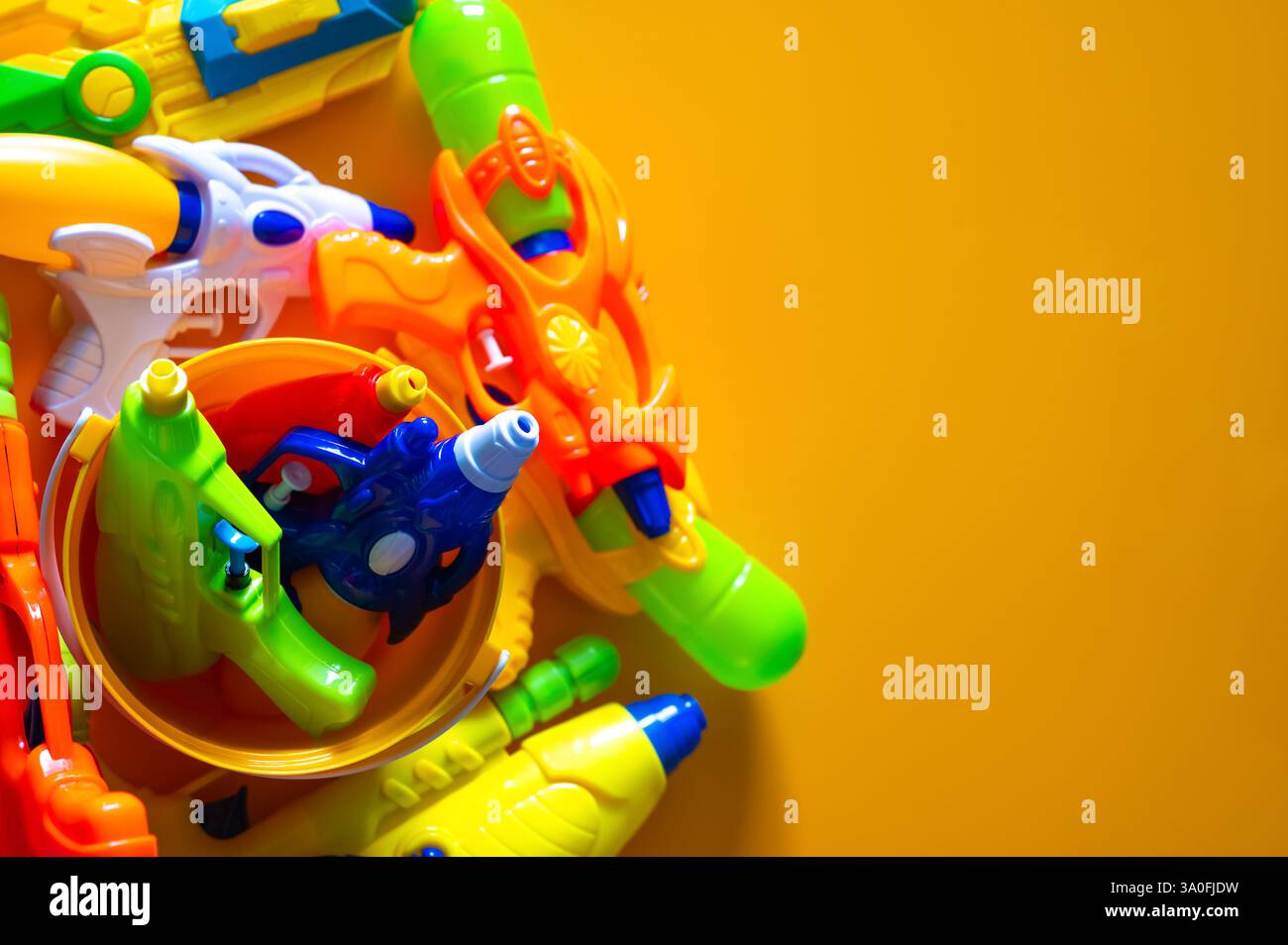 Water guns in yellow bucket and on yellow background for Thailand ...