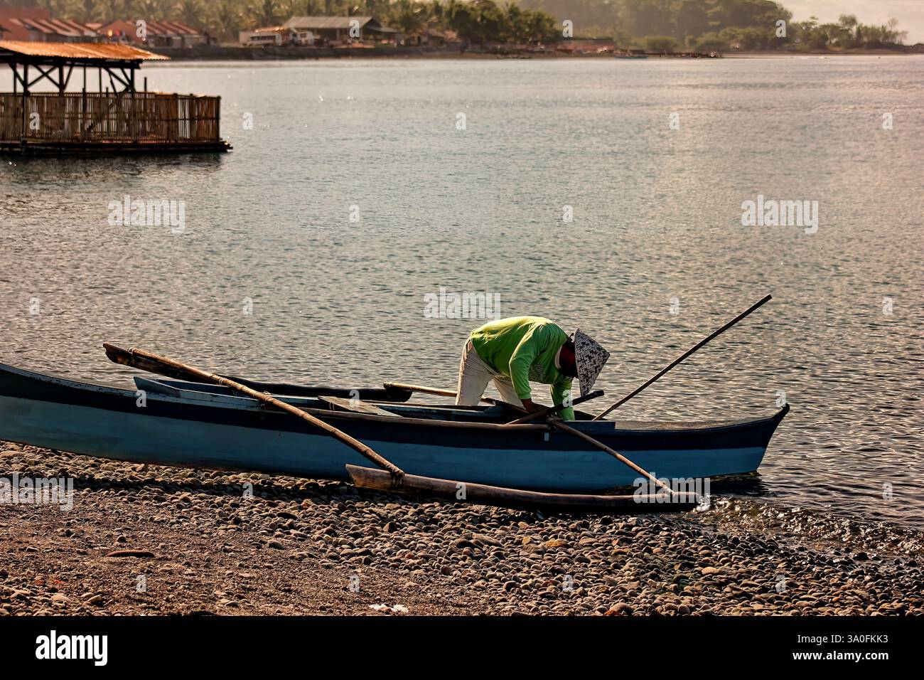 Fisherman beaches his rowboat and prepares to sell his catch at the ...