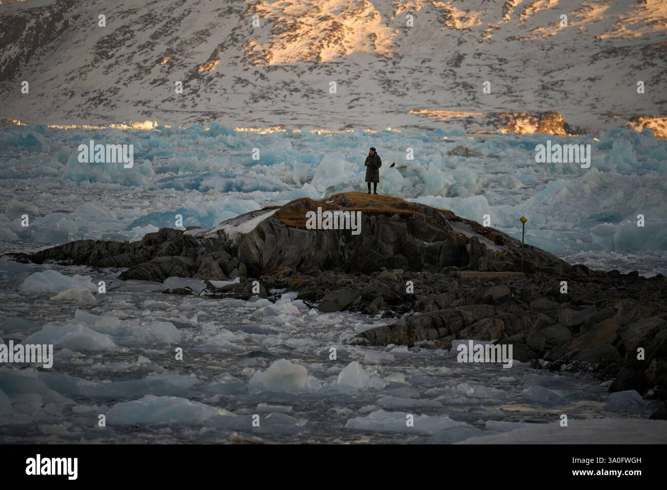 A resident watches as pieces of ice pile up blocking the access of the ...