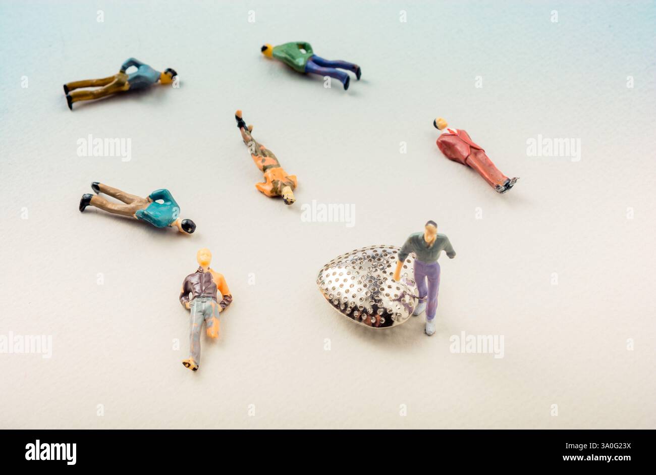 Tiny figurine of men with one attached to a heart icon Stock Photo - Alamy