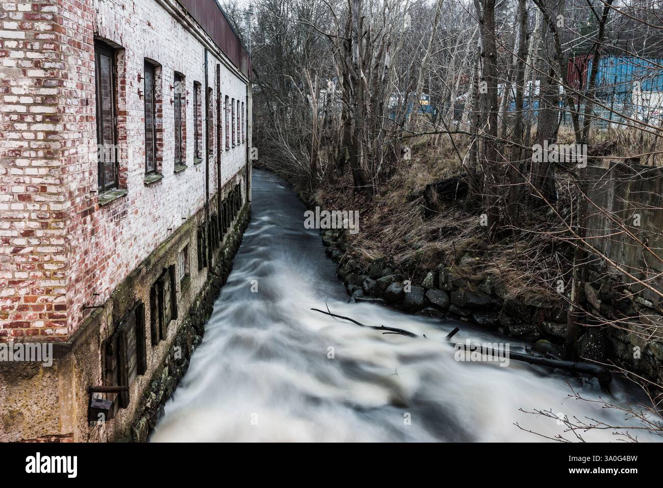 A rustic building stands beside a gently flowing river in Sweden, with ...