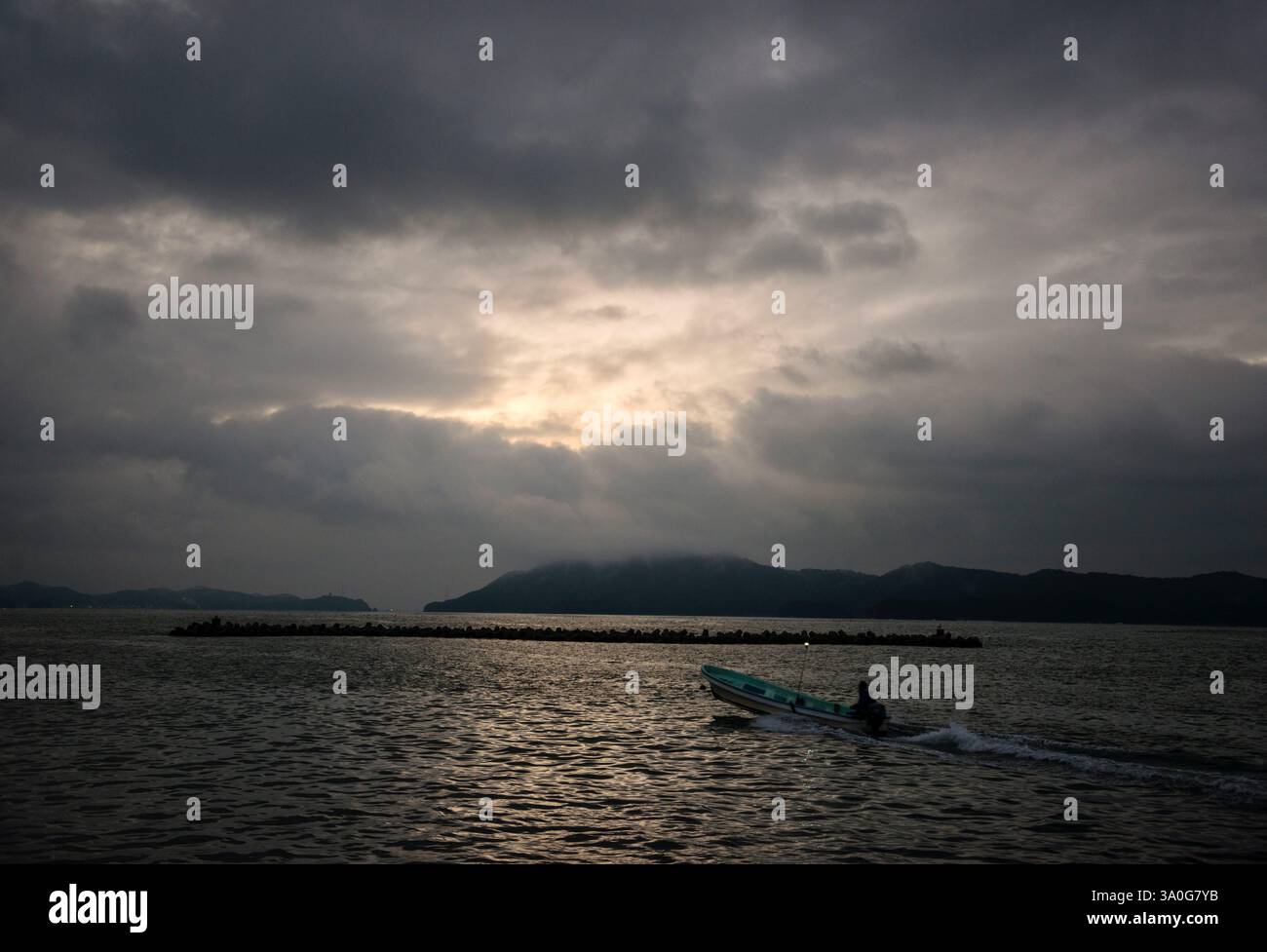 A fishing boat pulls out of port on Sugashima Island, Toba City, Mie ...