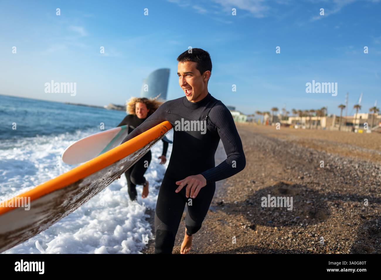 Beautiful happy surfer couple having fun on the beach, running with ...