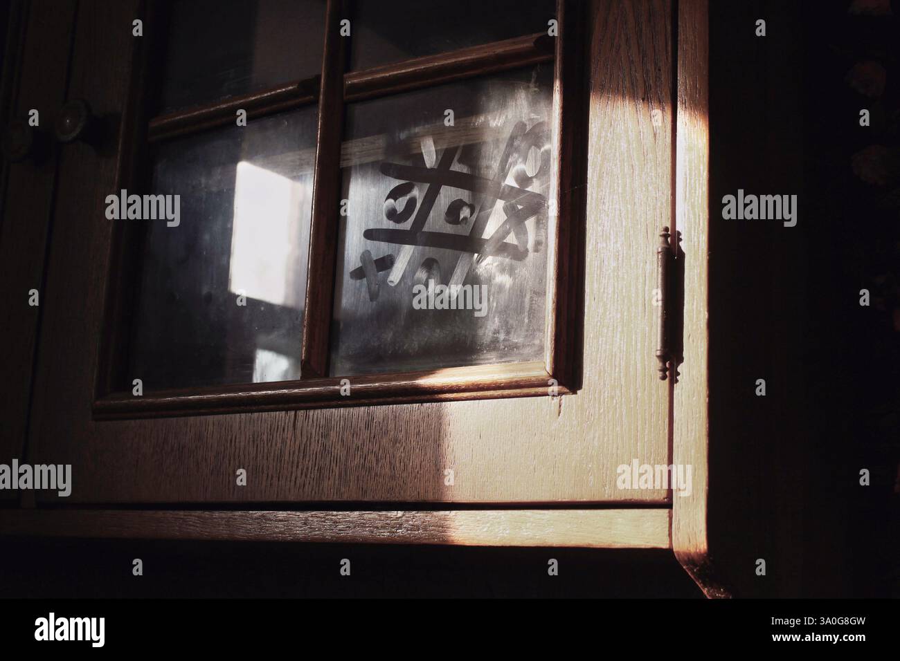 trace of a logic game drawing on the fogged glass of a cabinet in the ...
