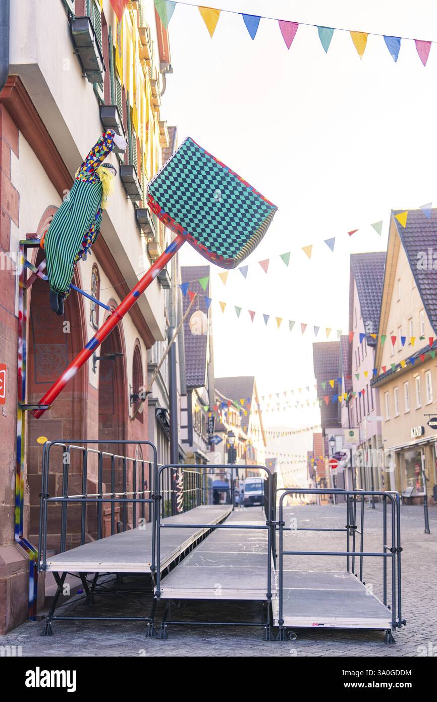 Set up stage with colourful flags in a decorated and festive street ...