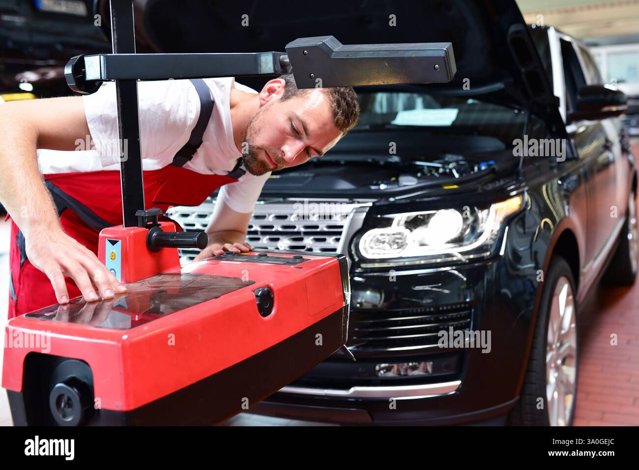 car repair shop - worker checks and adjusts the headlights of a car's ...