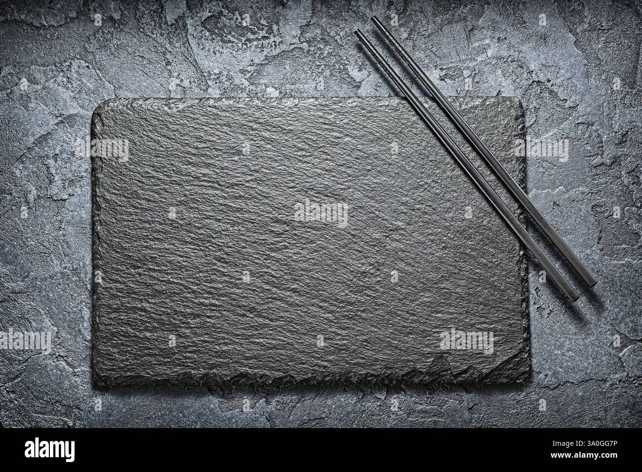 Black Choppingsticks On Stone Slate Plater Stock Photo - Alamy