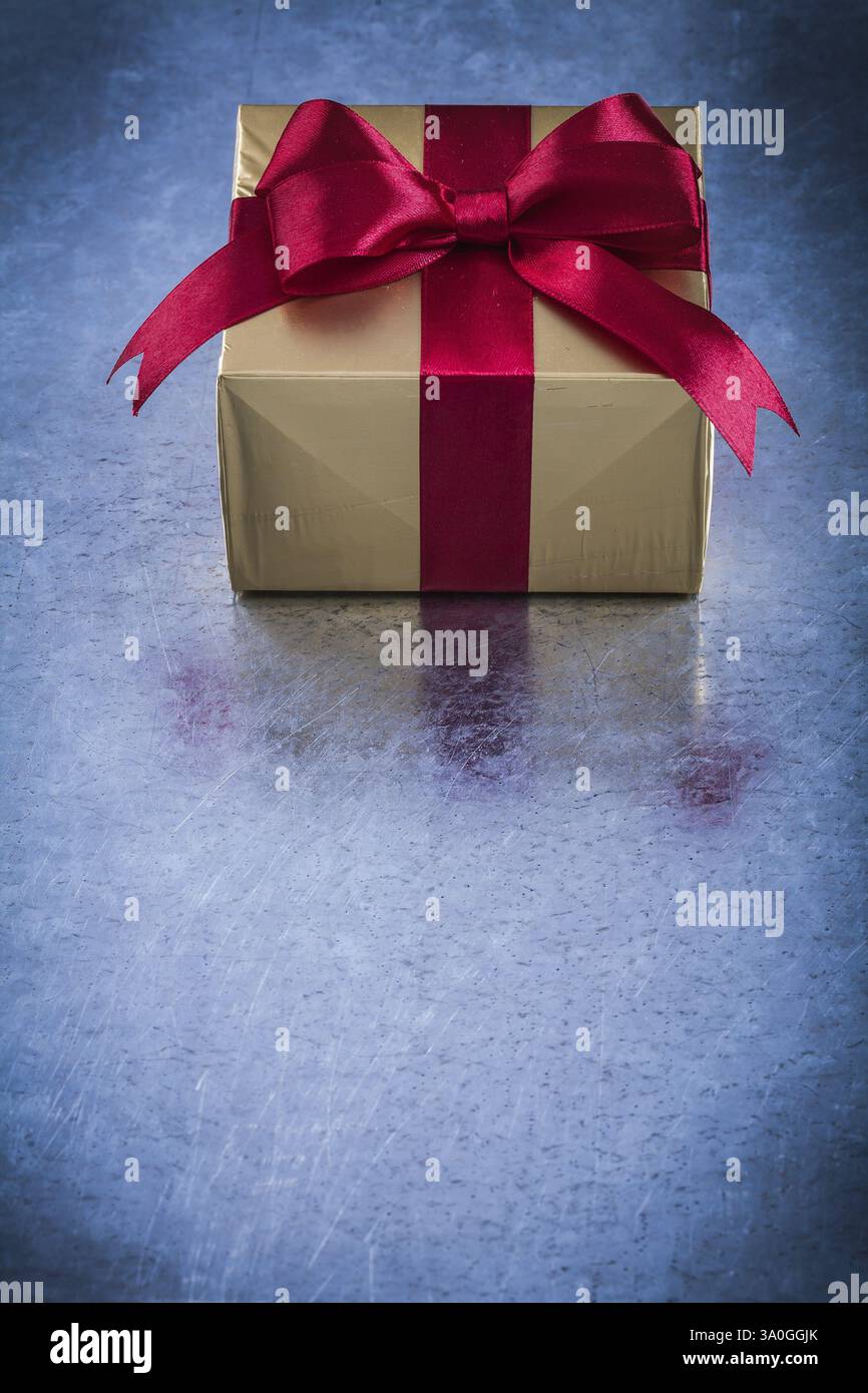 Boxed present with red ribbon on metallic background holiday concept ...