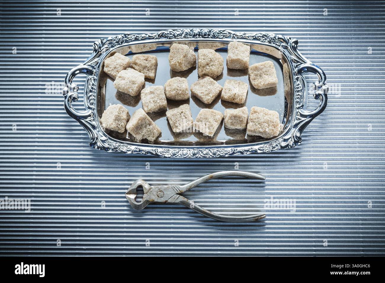 Brown sugar cubes pliers tray on striped background Stock Photo - Alamy