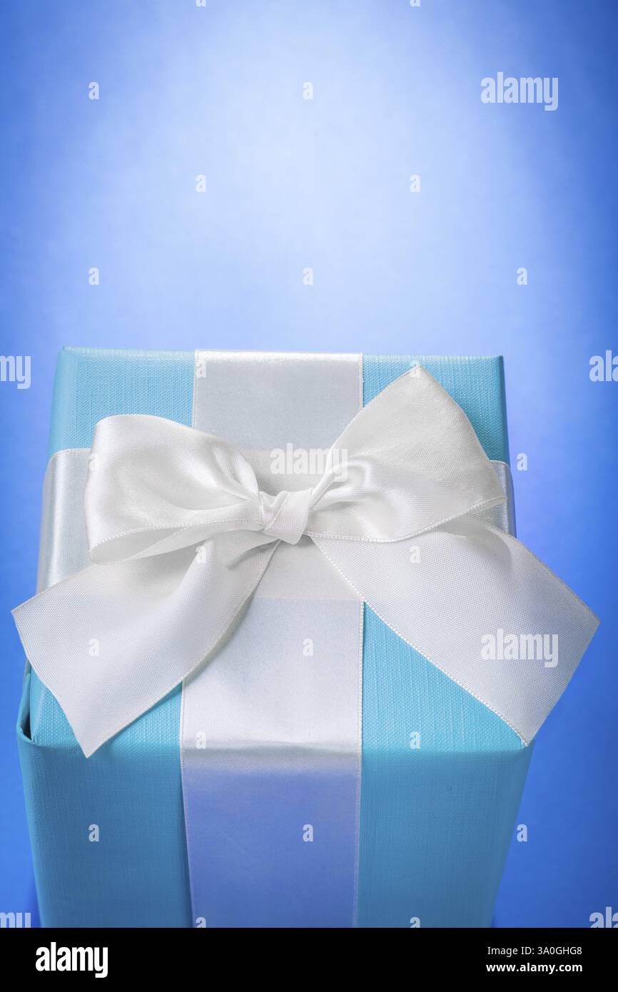 Blue gift box with white bow on bluee background with copyspace Stock ...