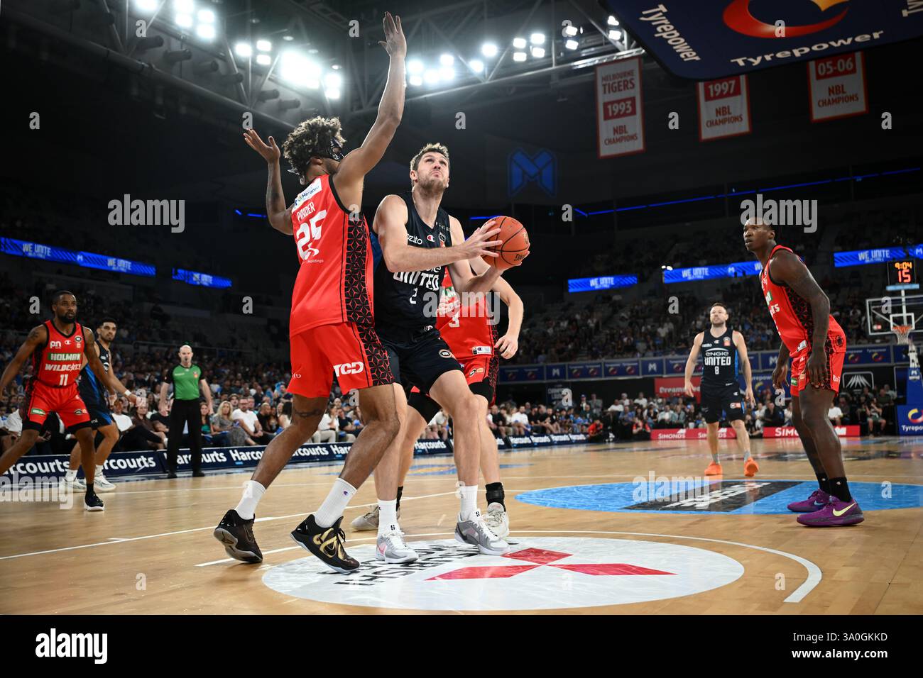 Robert Loe of Melbourne United (centre) drives for the basket during ...