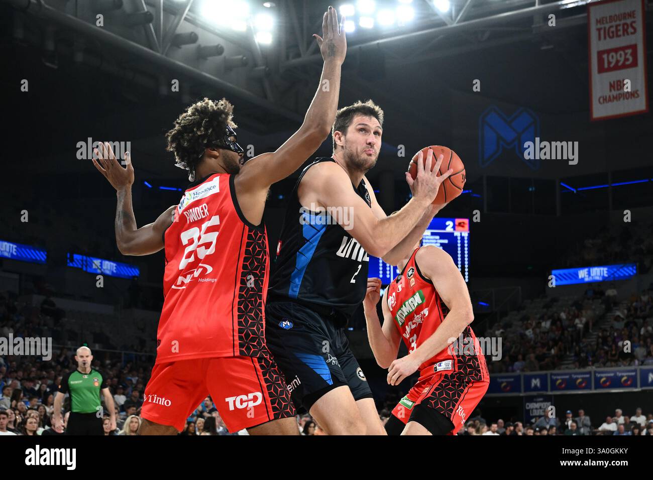 Robert Loe of Melbourne United (centre) drives for the basket during ...