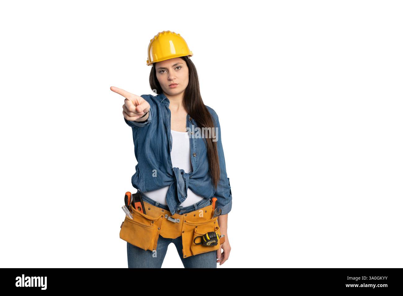 A determined female construction worker wearing a yellow hard hat and ...