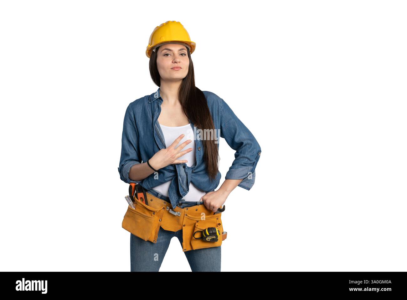 A determined female construction worker wearing a yellow hard hat and ...
