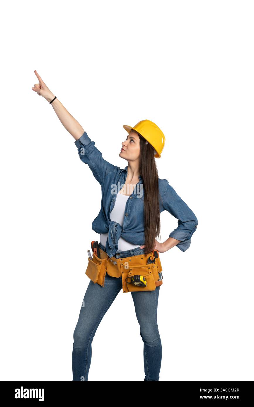 A determined female construction worker wearing a yellow hard hat and ...