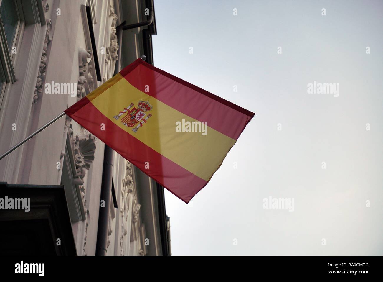 spanish flag waving on building on blue sky background Stock Photo - Alamy