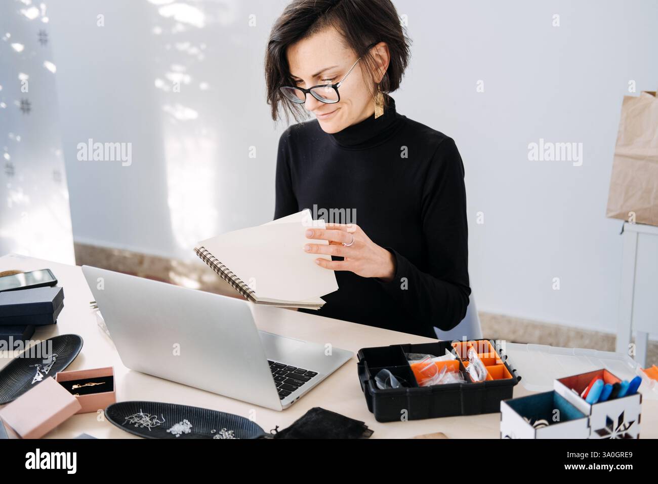 Home-based jewelry business owner planning and managing her brand. Creative workspace, remote ...