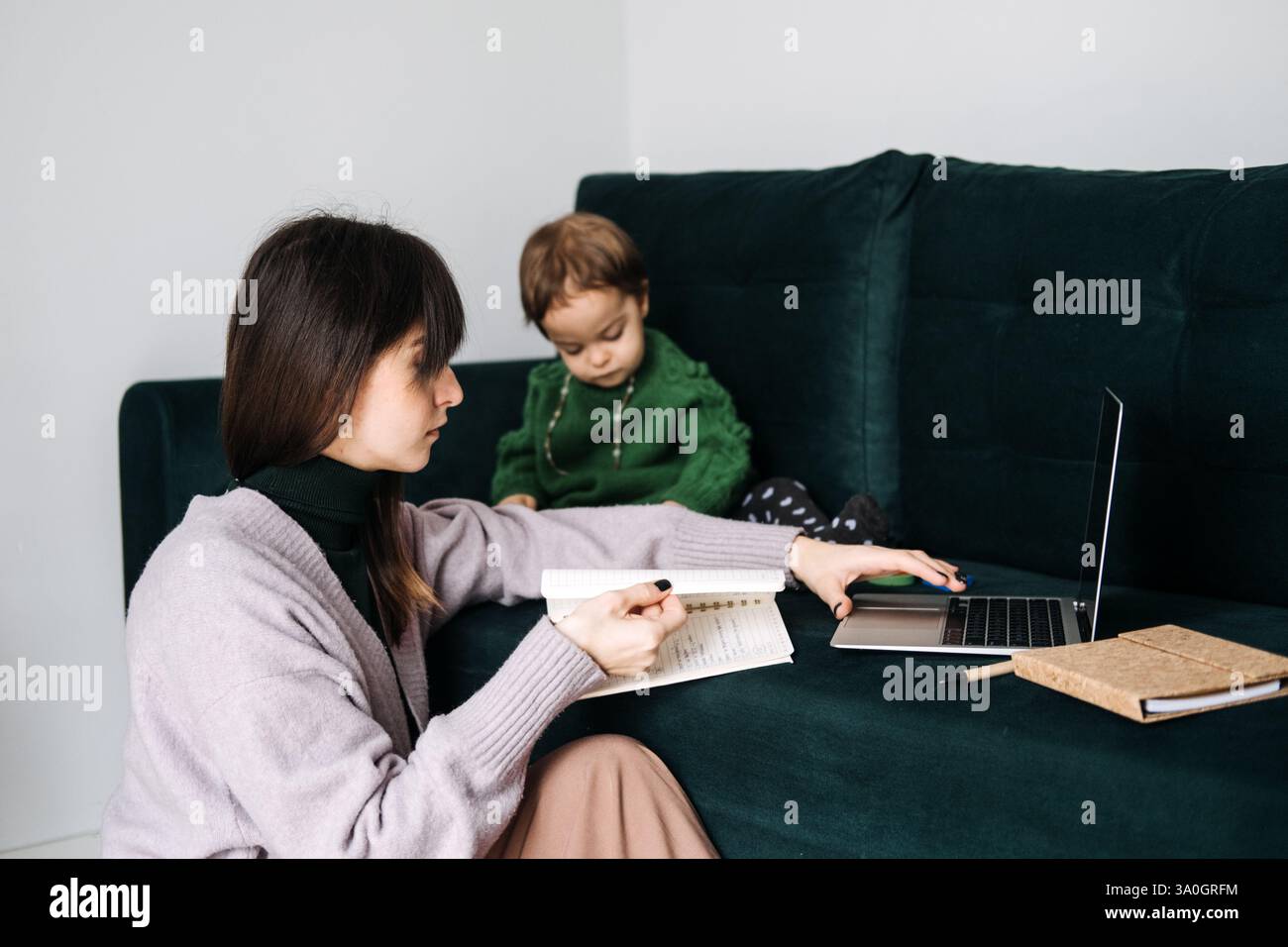 Mother working remotely with toddler on couch. Remote work challenges ...
