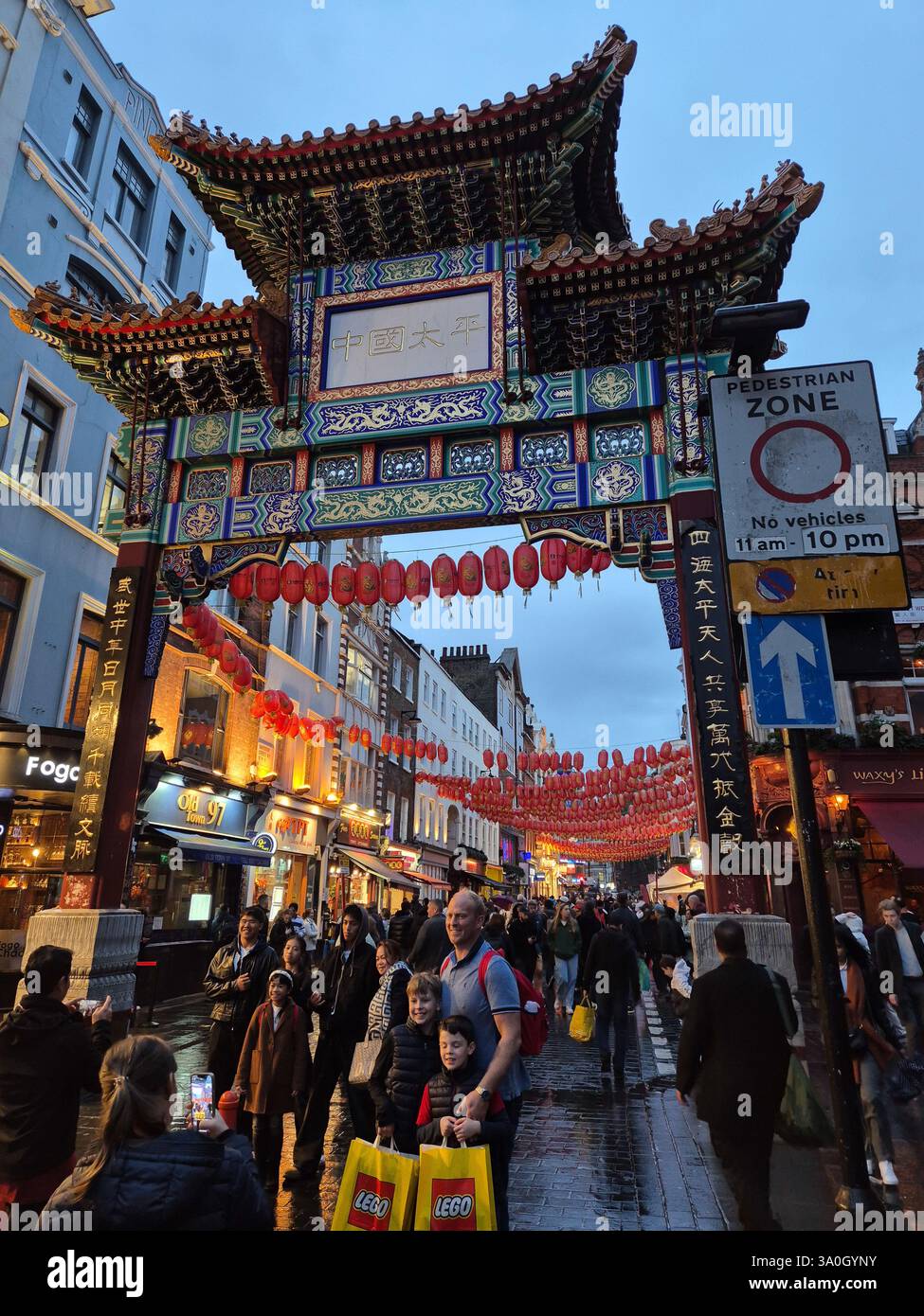 Crowd of people passing through the busy Soho area in London UK See ...