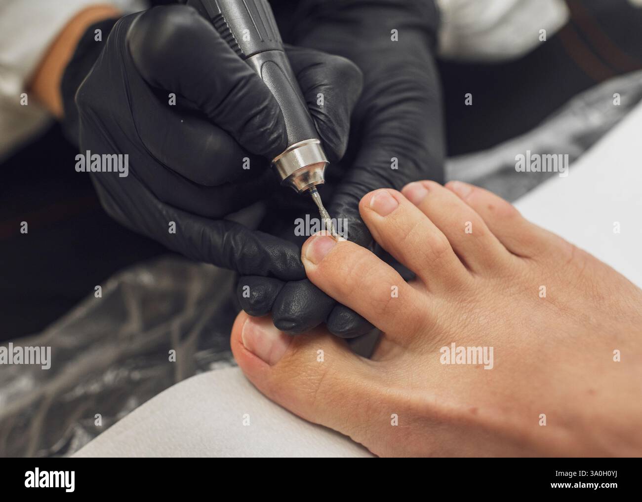 The master performs a hardware pedicure in a beauty salon. Processing ...