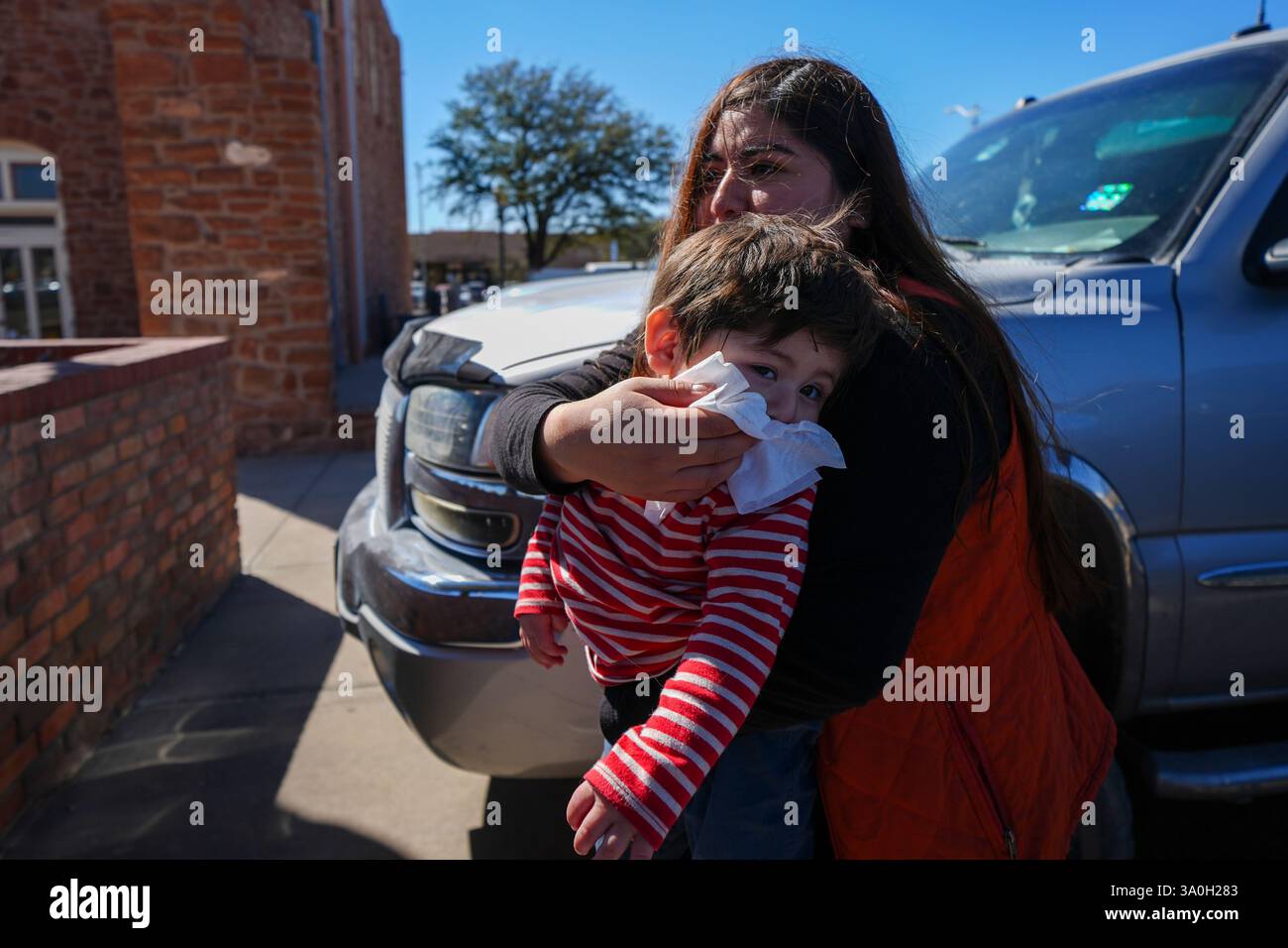 Jennifer Sanchez wipes the face of her 1-year-old son Saul Escamilla ...