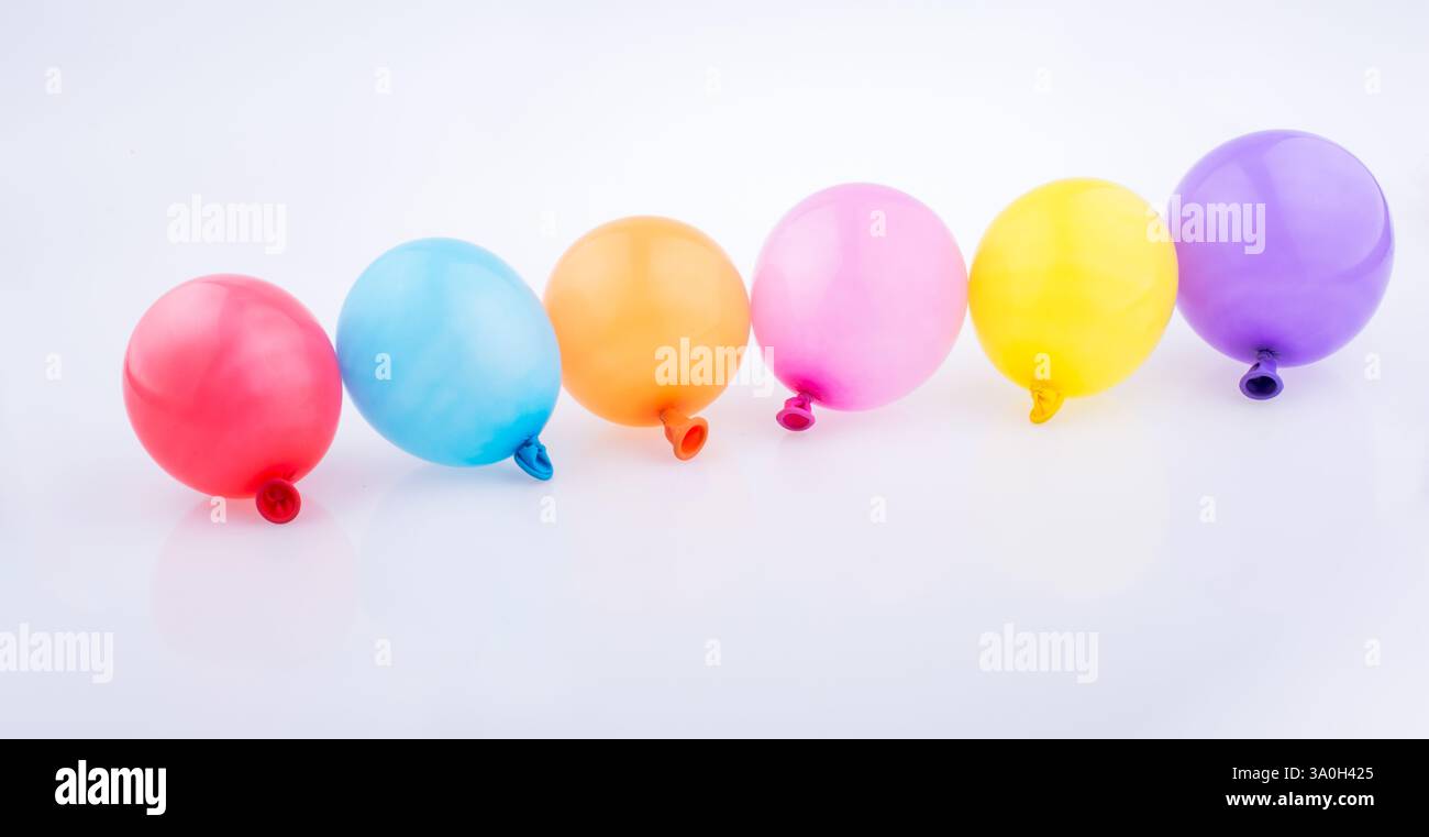 Colorful small balloons in line on a white background Stock Photo - Alamy